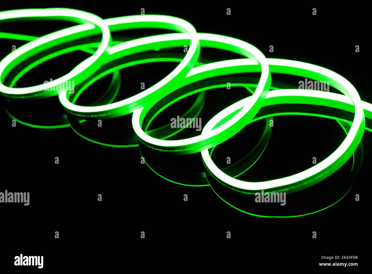 Image of vibrant spiral green neon glow sticks over black background ...