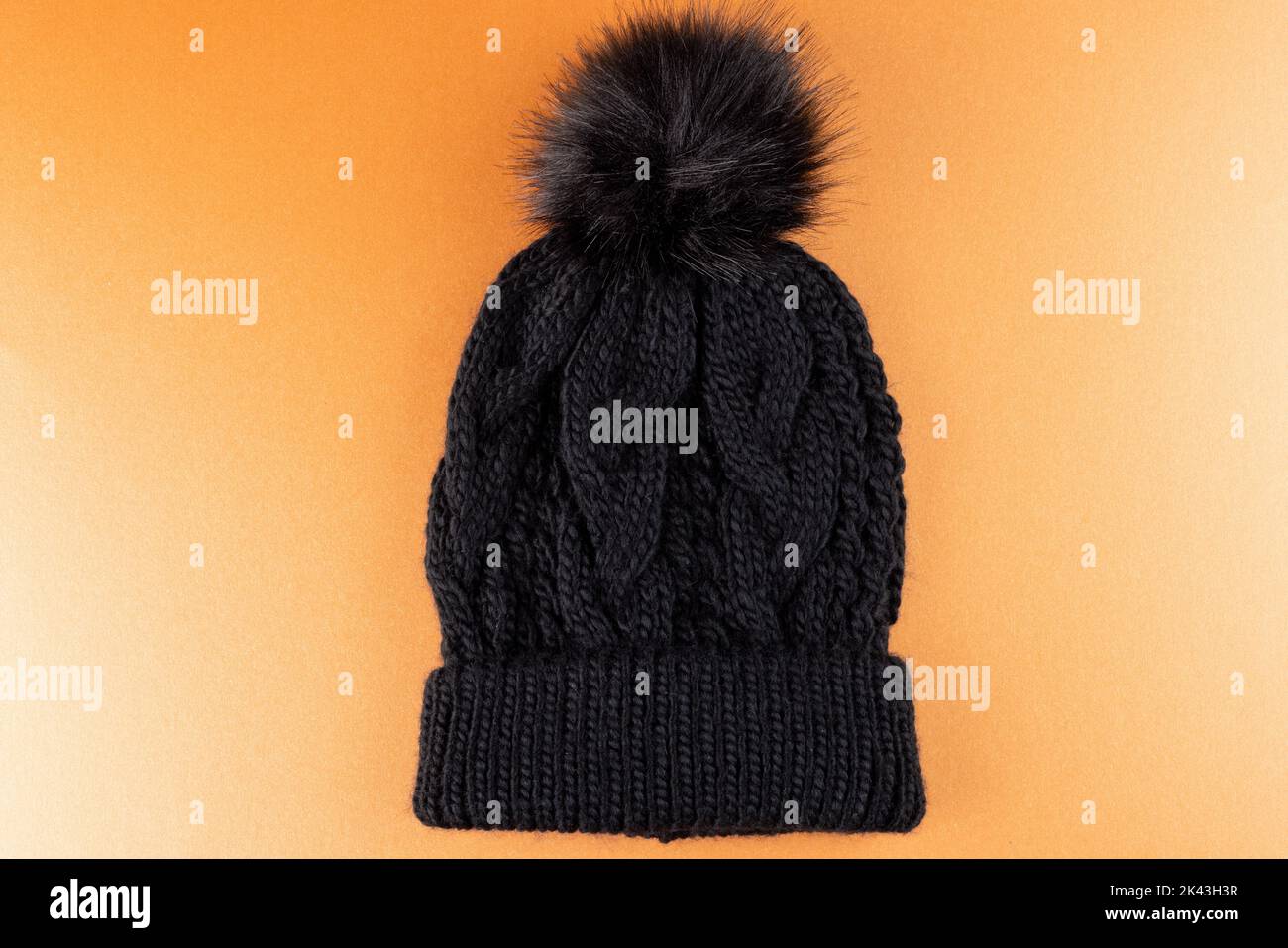 Image of wool beanie with pom pom on yellow surface Stock Photo - Alamy