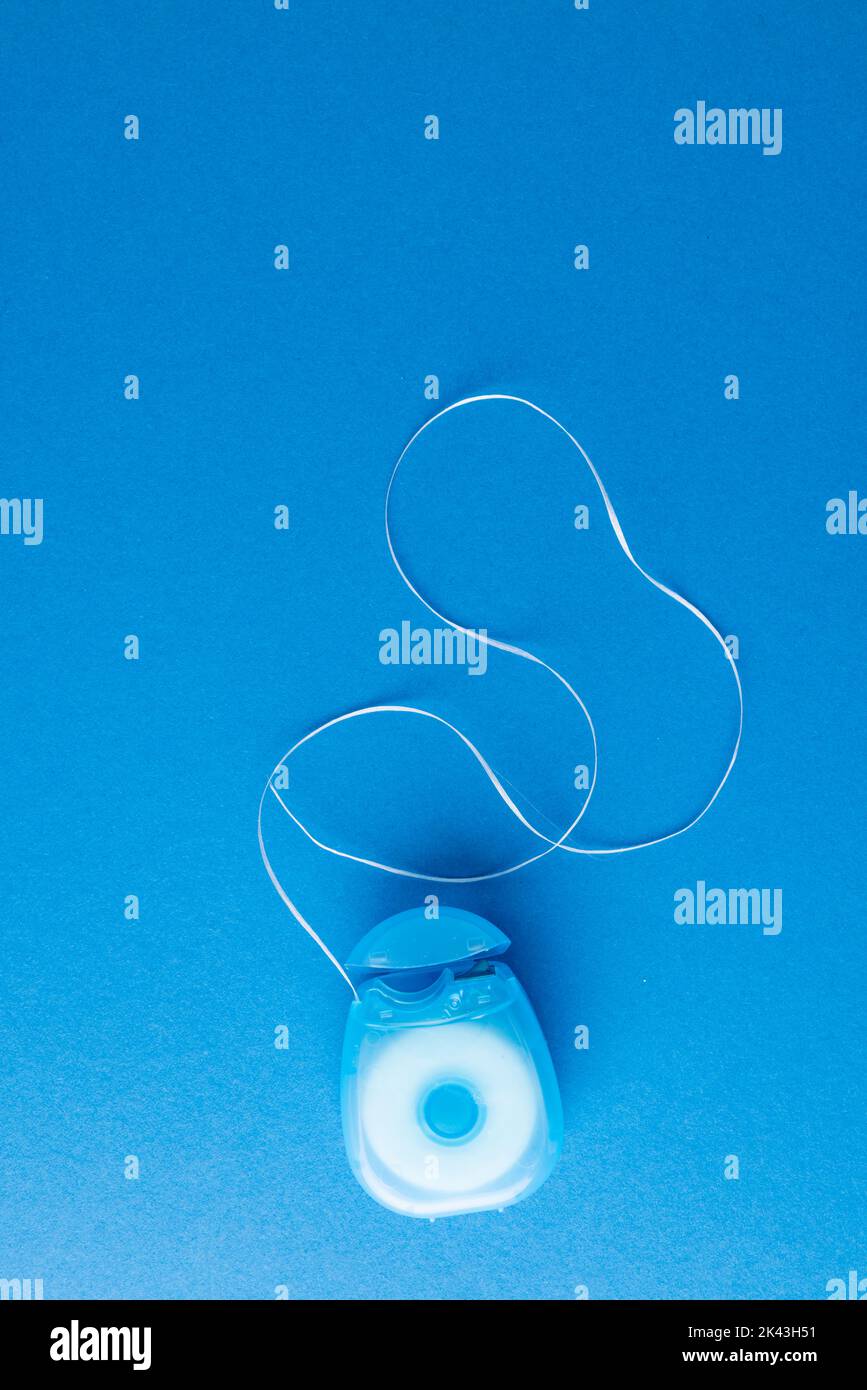 Vertical image of dental string on blue surface Stock Photo - Alamy