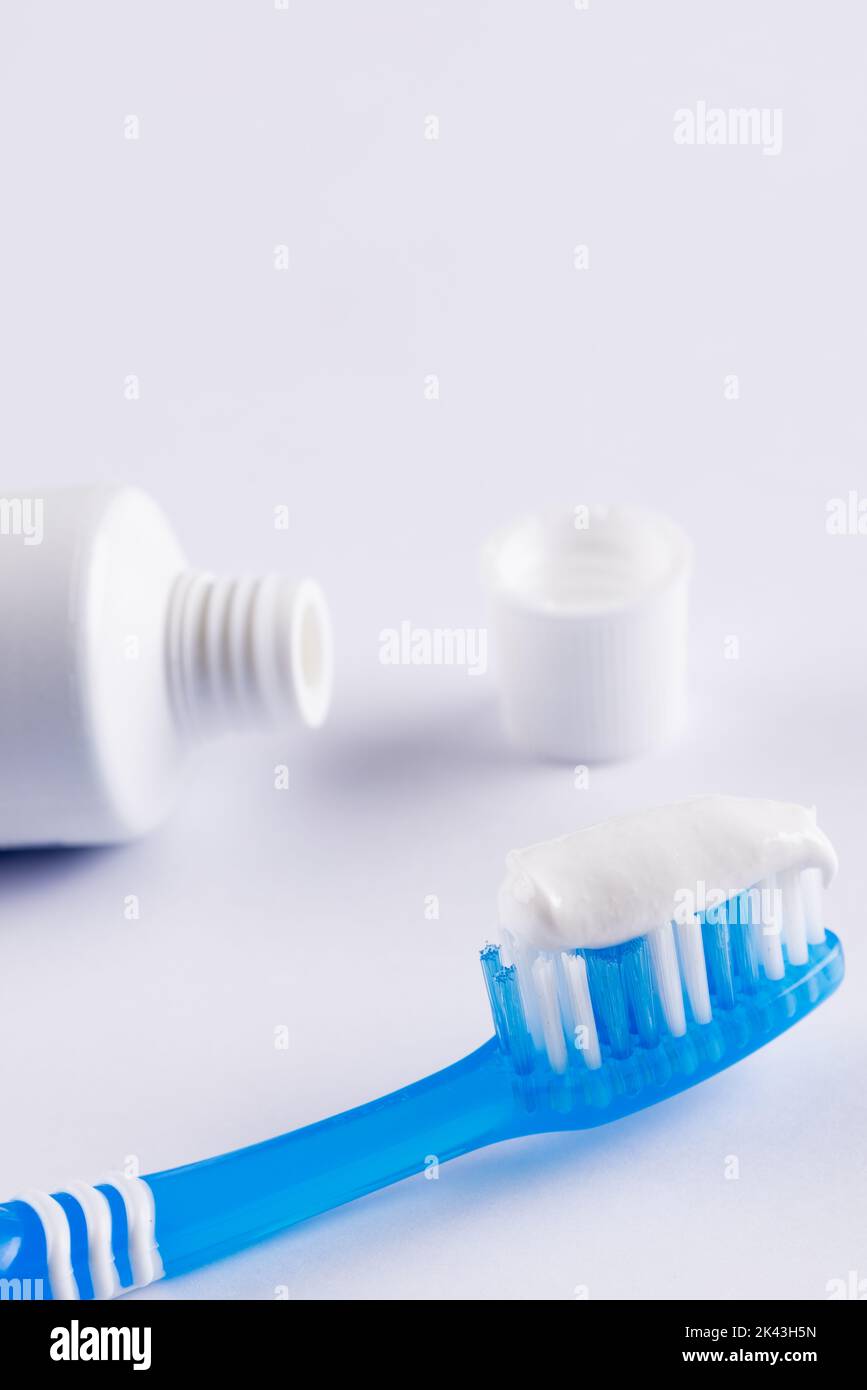 Vertical image of toothbrush and toothpaste on white surface Stock ...