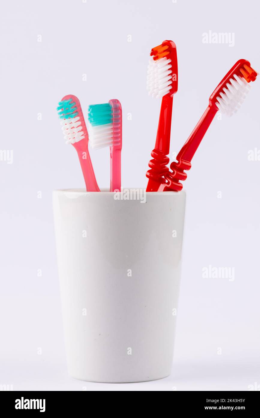 Vertical image of toothbrushes in cup on grey background Stock Photo ...