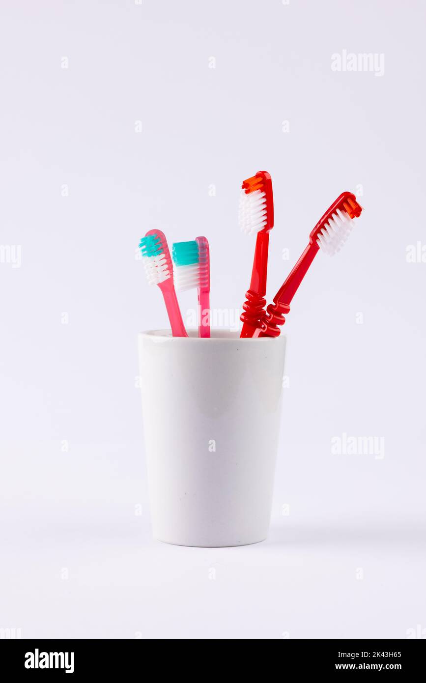 Vertical image of toothbrushes in cup on grey background Stock Photo ...