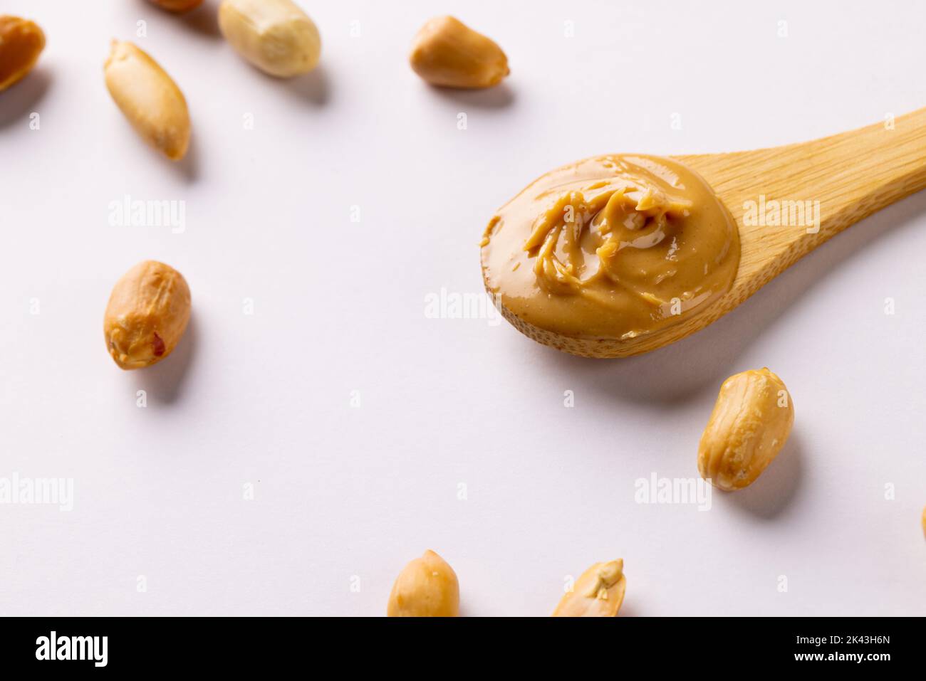 Image of spoon with peanut butter and nuts on white surface Stock Photo ...