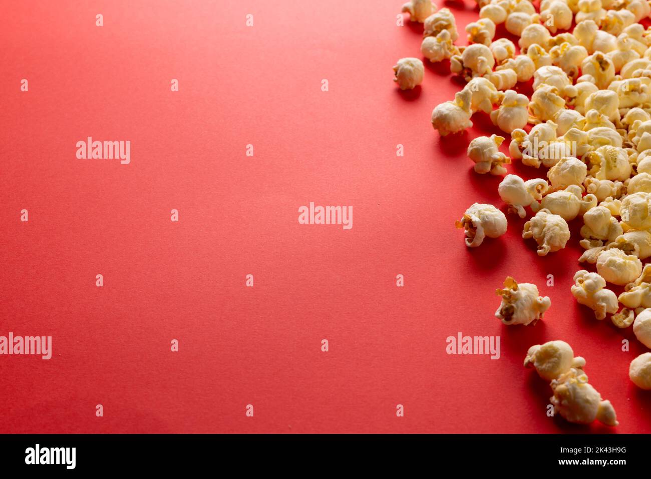 Image of pop corn lying on red surface Stock Photo - Alamy
