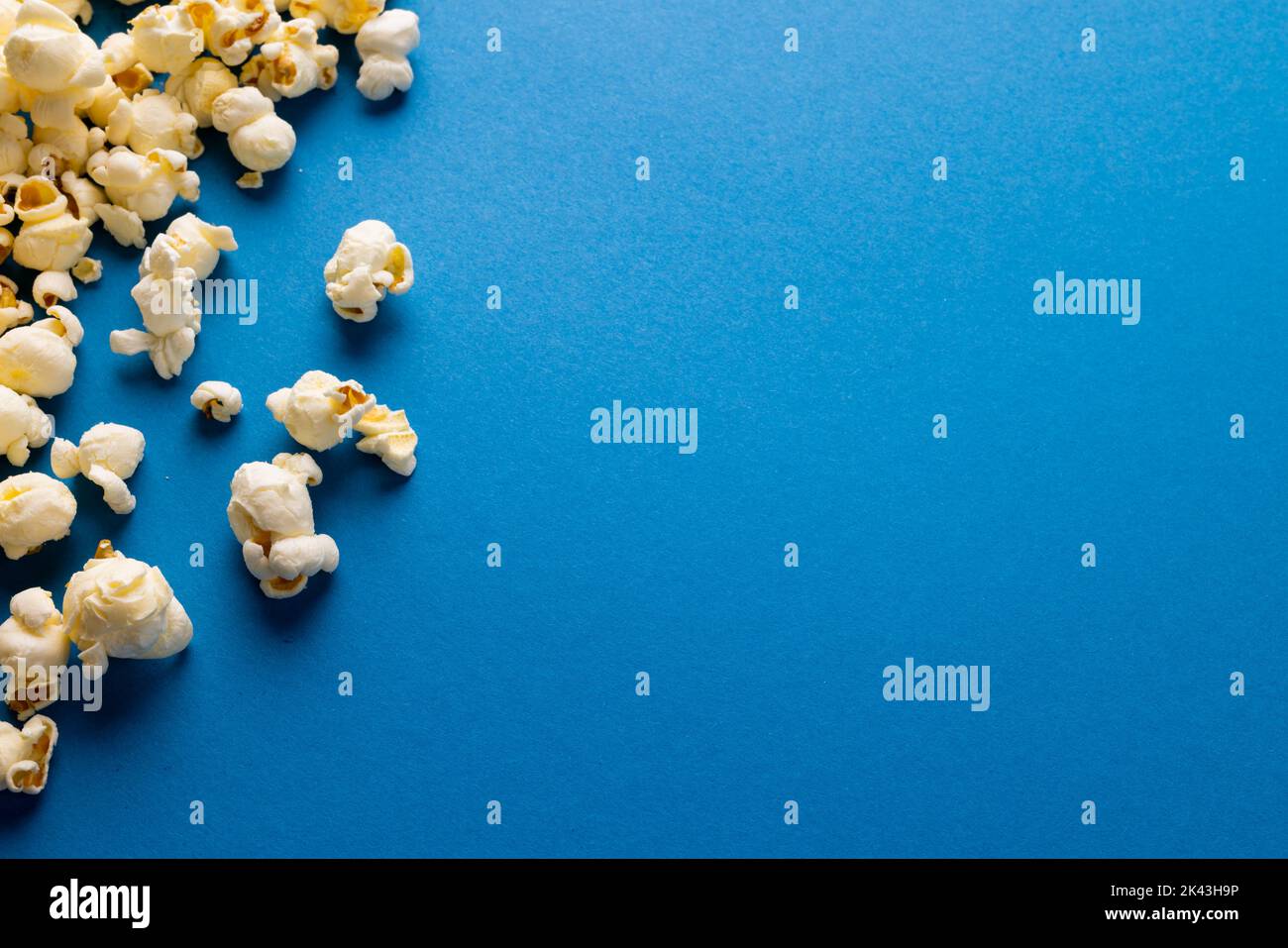 Image of pop corn scattered on blue surface Stock Photo - Alamy