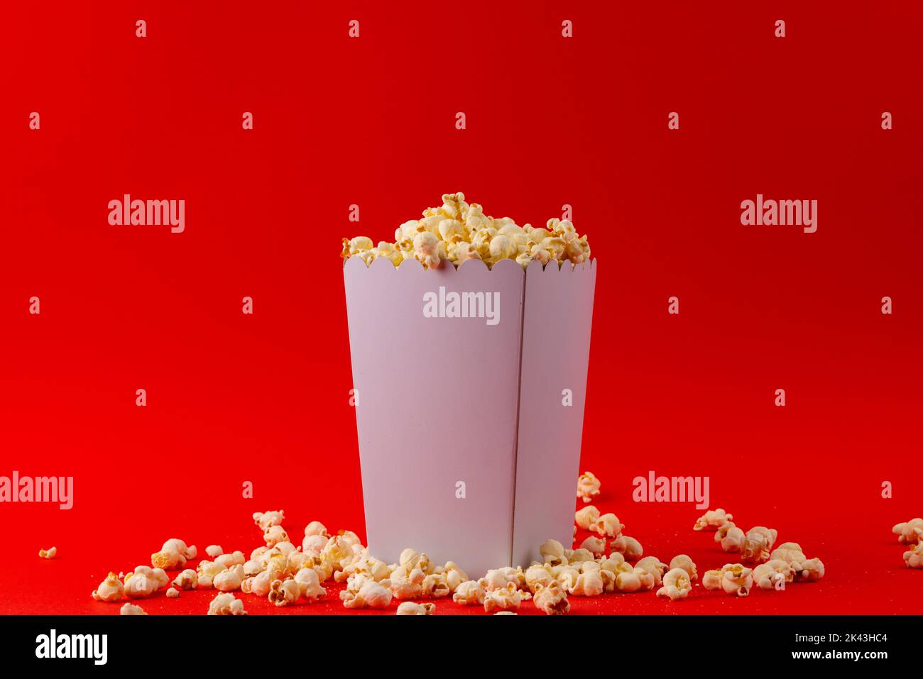 Image of pop corn in box on red surface Stock Photo - Alamy