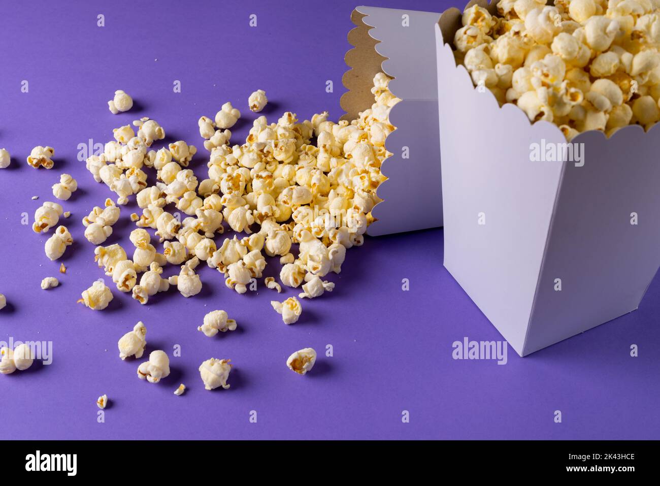 Image of pop corn in boxes and scattered on violet background Stock ...