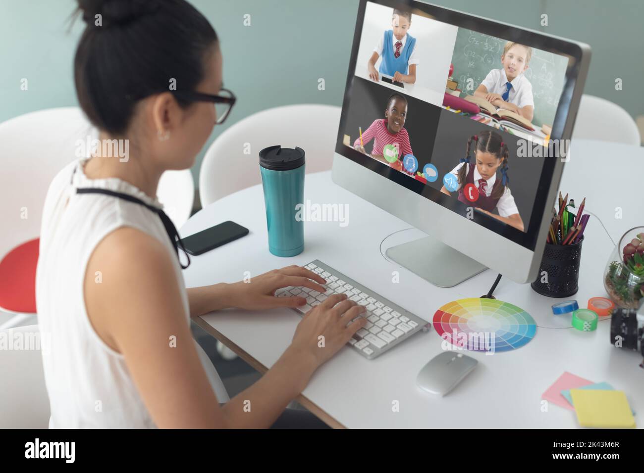 Female teacher having a video conference with multiple students on ...