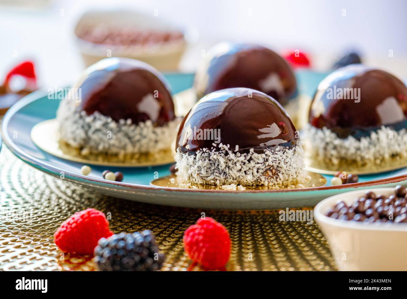 Chocolate round cake with raspberry set on a blue plate and chocolate ...