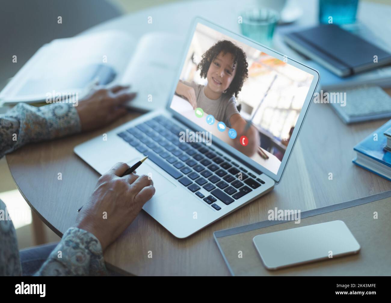 Mid section of female teacher having a video call with male student on ...