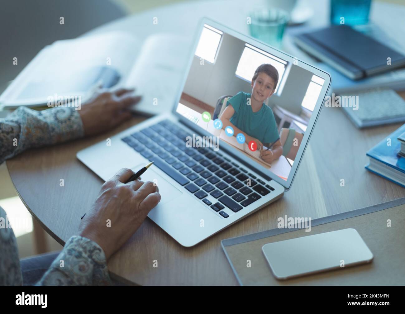 Mid section of female teacher having a video call with male student on ...