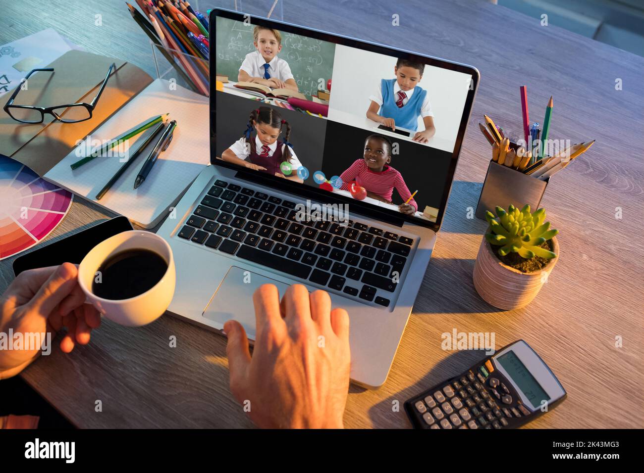 Mid section of teacher having a video conference with multiple students ...