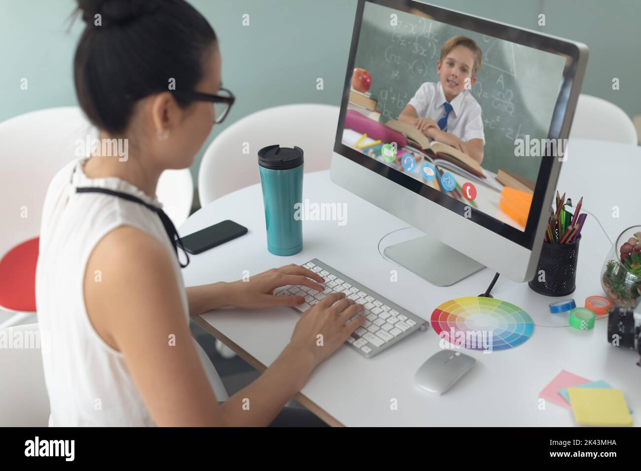 Female teacher having a video call with male student on computer at ...