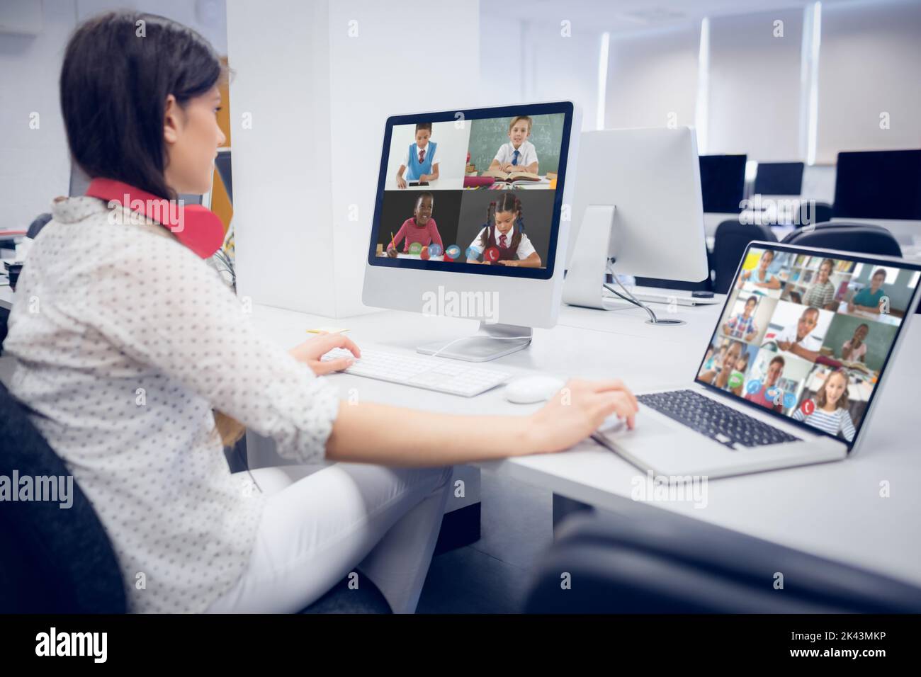 Female teacher wearing headphones having a video call with multiple ...