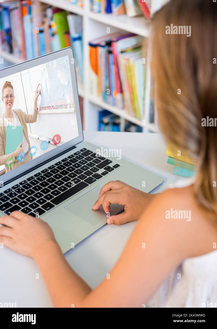 Female student having a video call with female teacher on laptop at the ...