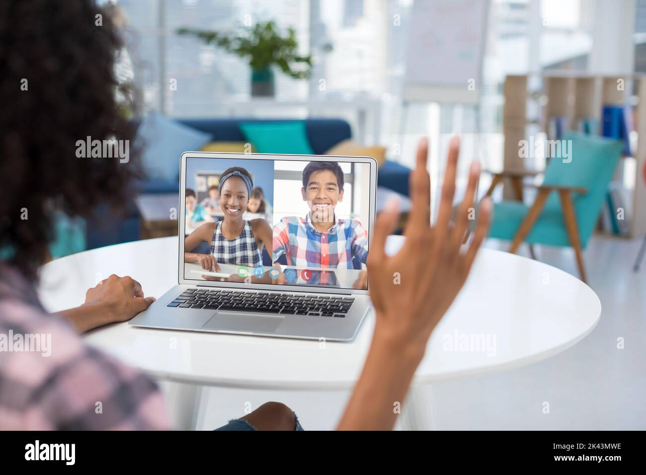 Female teacher having a video call with male and female student on ...