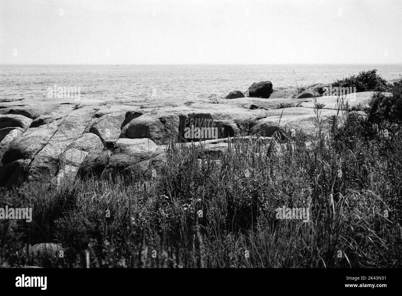 A wood sign reading Private is posted on the rocky shore at the Nubble ...