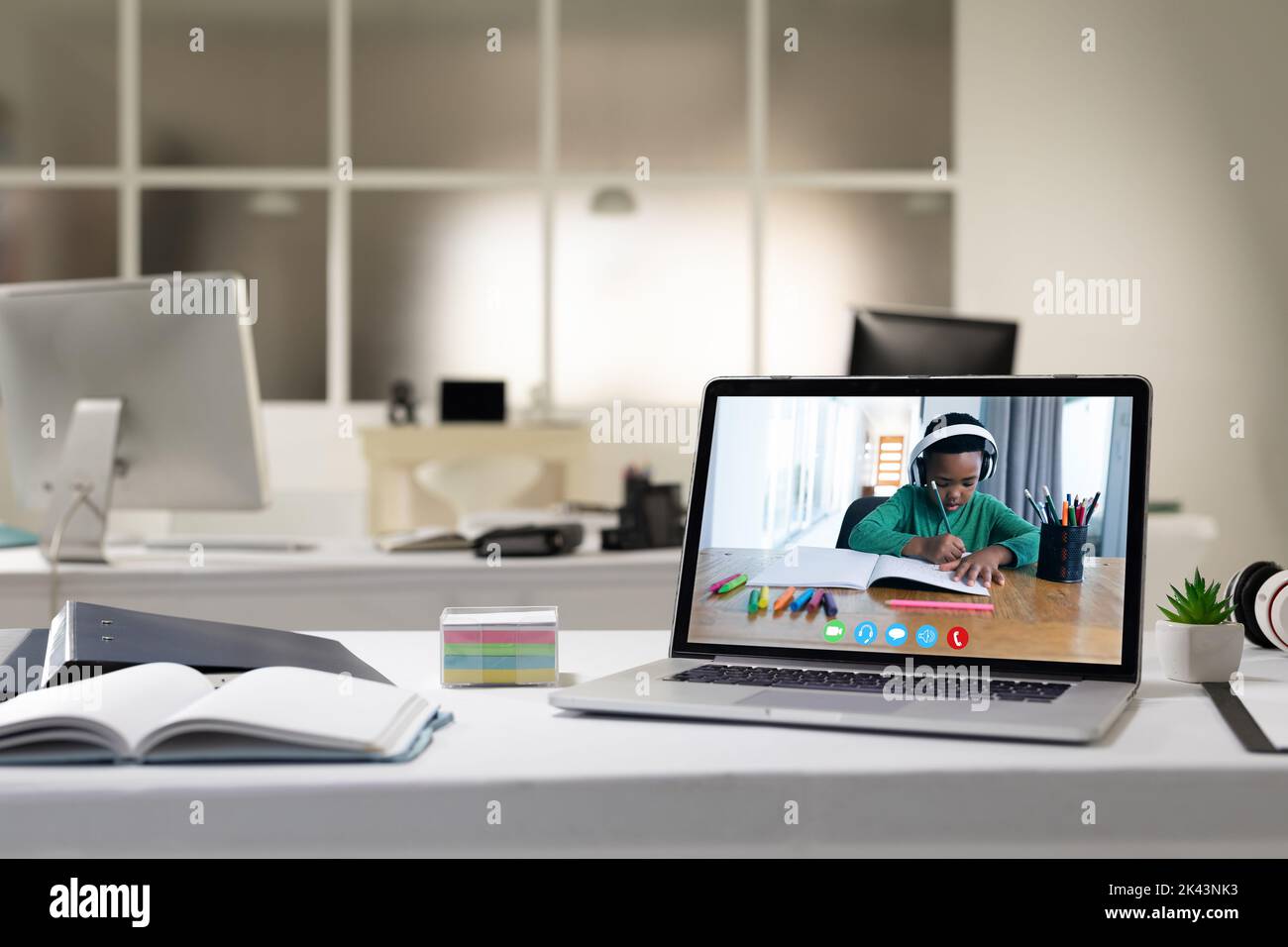 African american boy having online lesson on screen of laptop on desk ...