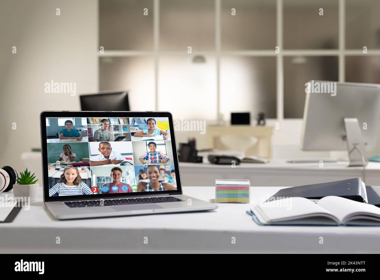 Diverse group of students having video call on screen of laptop on desk ...