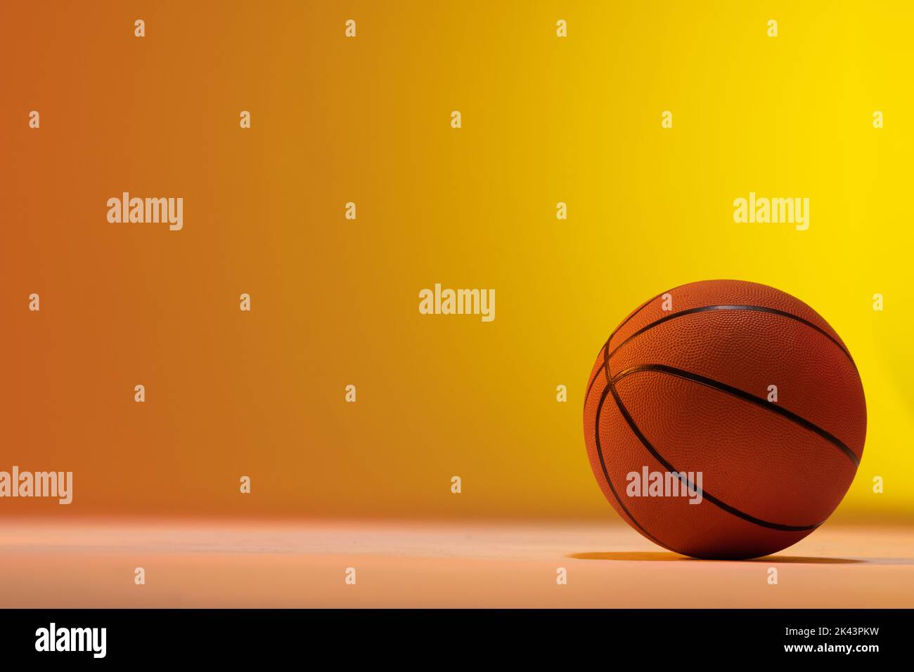 Image of orange basketball with copy space on orange to yellow ...