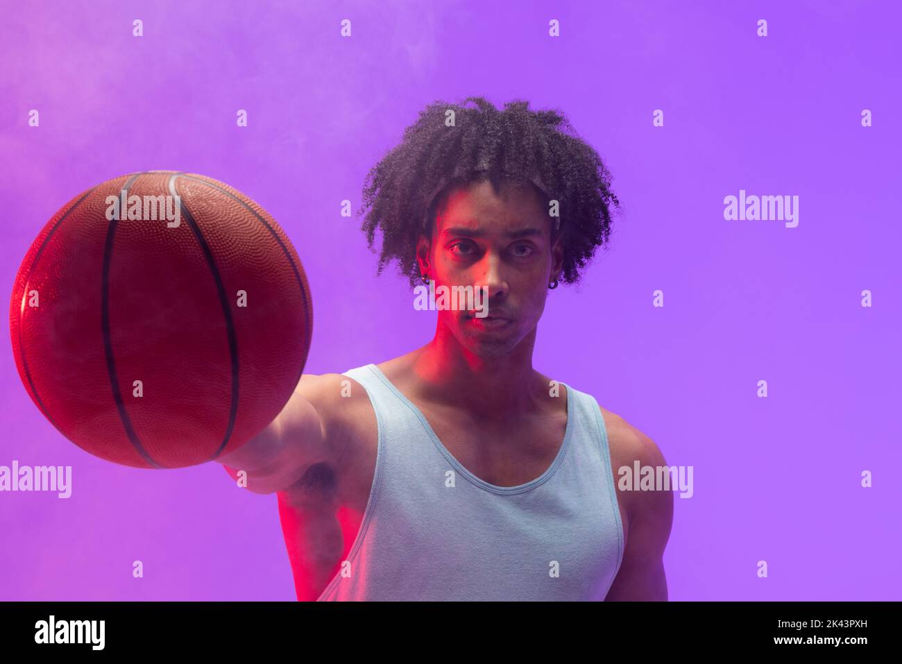 Image Of Biracial Basketball Player With Basketball On Neon Purple