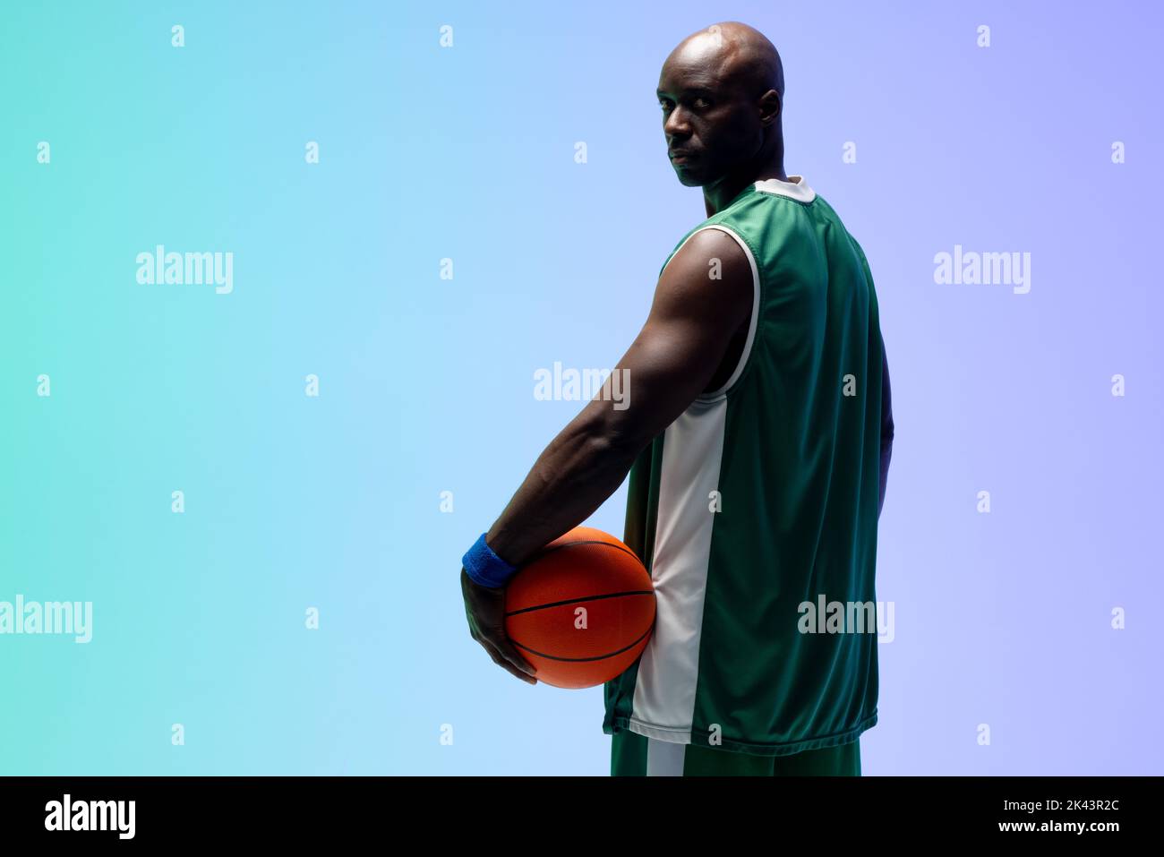 Image of african american basketball player with basketball on green to ...