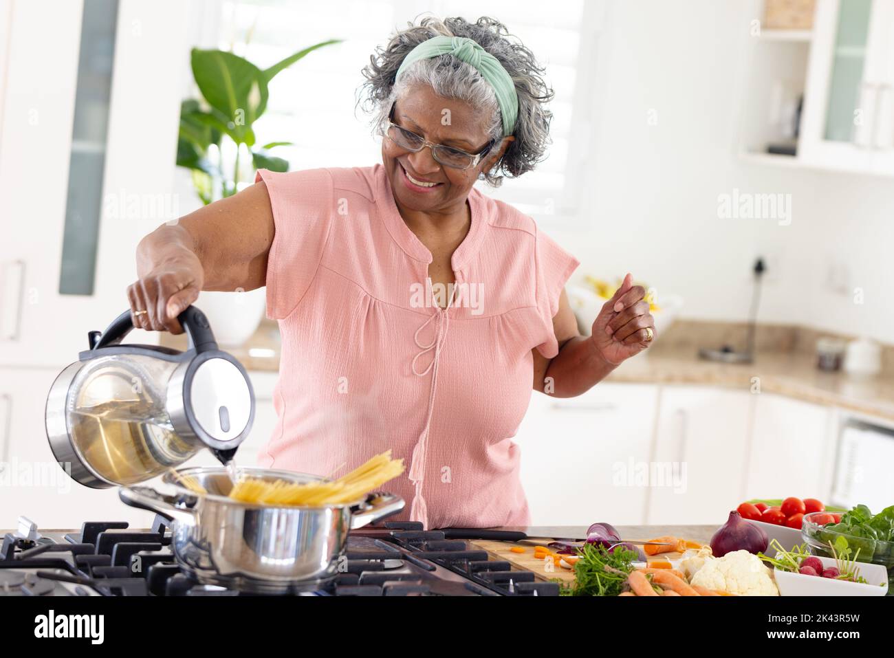 Happy senior african american women cooking alone in the kitchen Stock ...