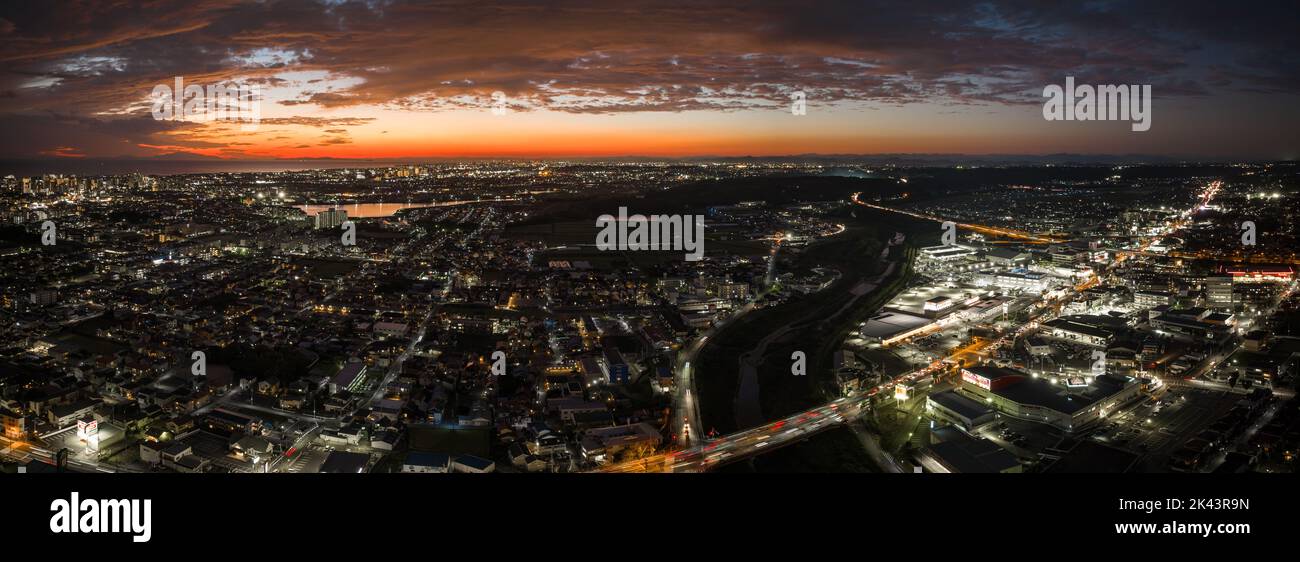 Panoramic aerial view of sunset over lights from city grid Stock Photo ...