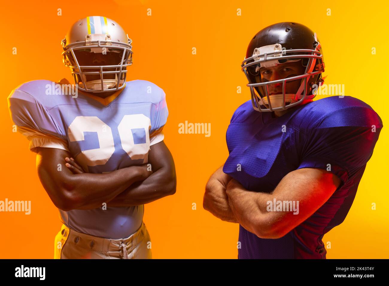 Diverse male american football players wearing helmets with neon orange ...