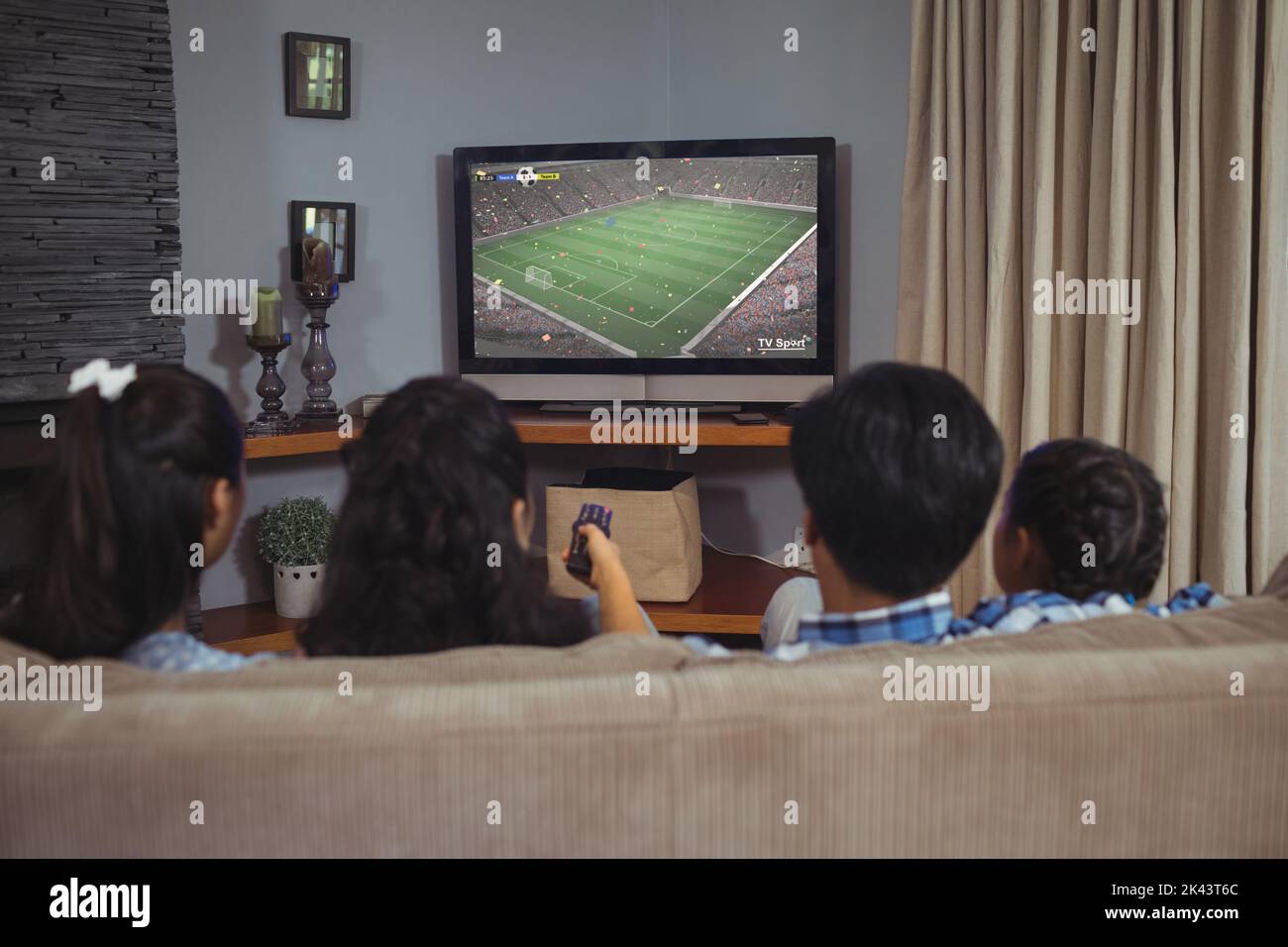 Diverse children watching tv with football match on screen Stock Photo ...