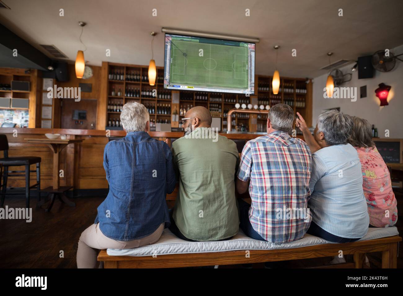 Senior diverse friends supporting and watching tv in bar with football ...