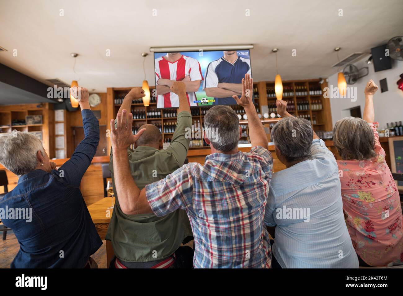 Senior diverse friends supporting and watching tv in bar with football ...