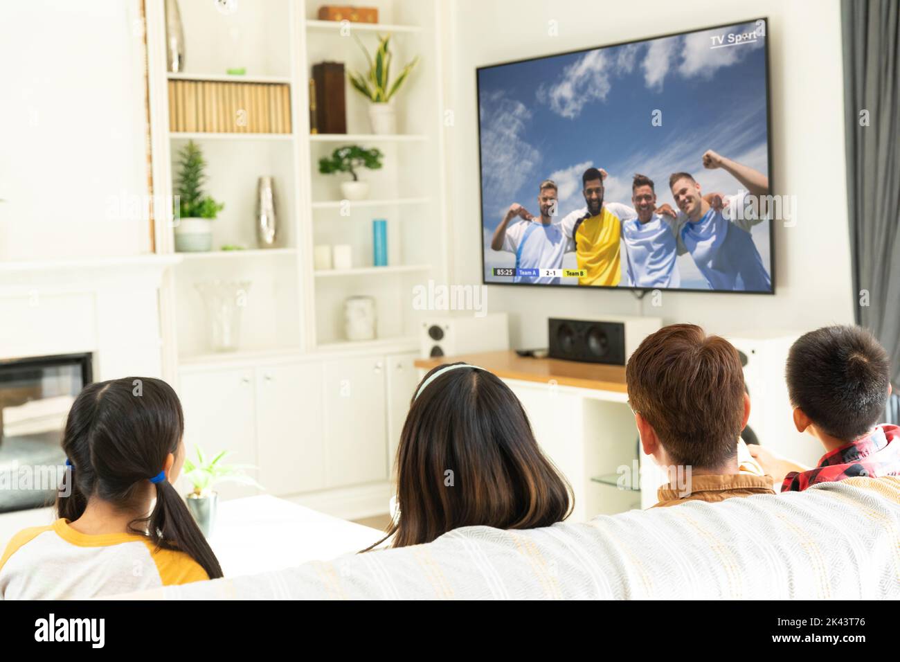 Diverse children watching tv with football match on screen Stock Photo - Alamy