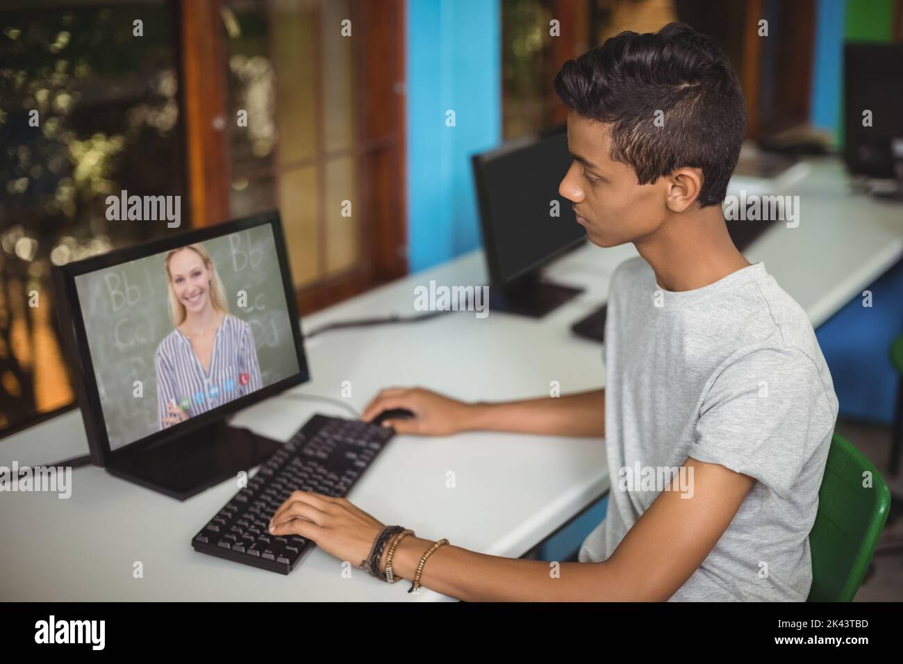 Male indian student having a video call with female teacher on computer ...