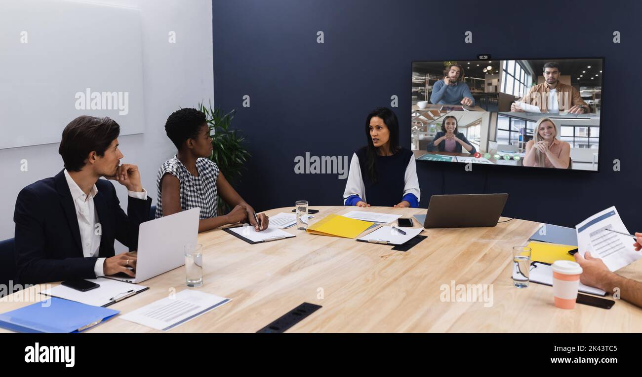 Diverse group of business colleagues having video call on screen in ...