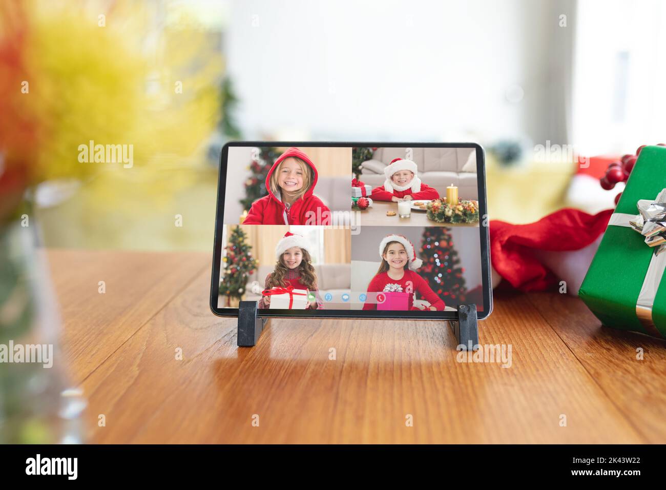 Four smiling caucasian girls in santa hats on tablet christmas group ...