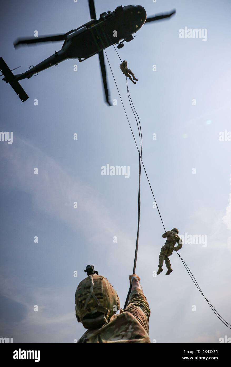 A U.S. Soldier belays a cable as Soldiers rappel from a UH-60 Black ...