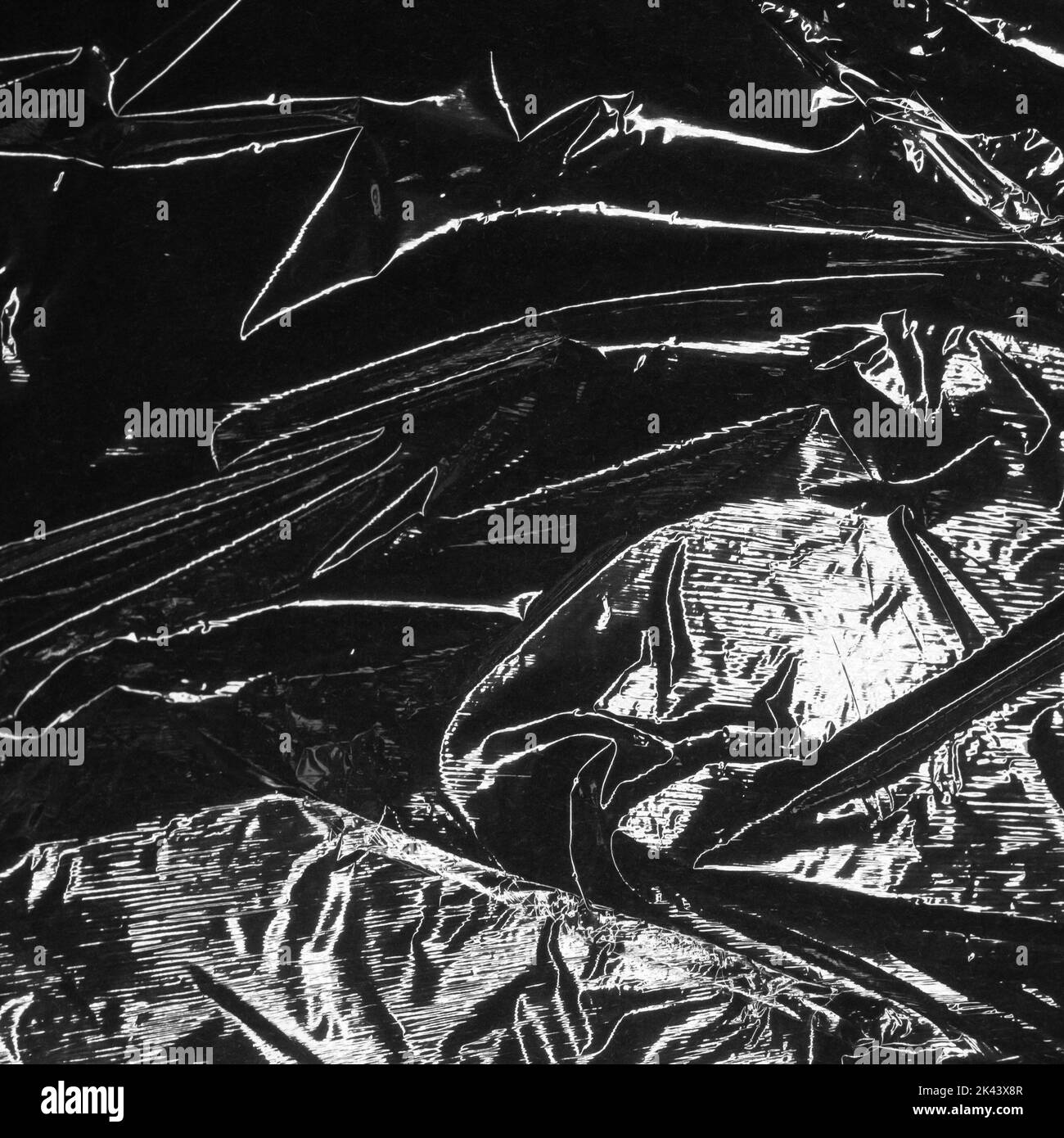 Reflecting light and shadow on creases and folds in black plastic ...