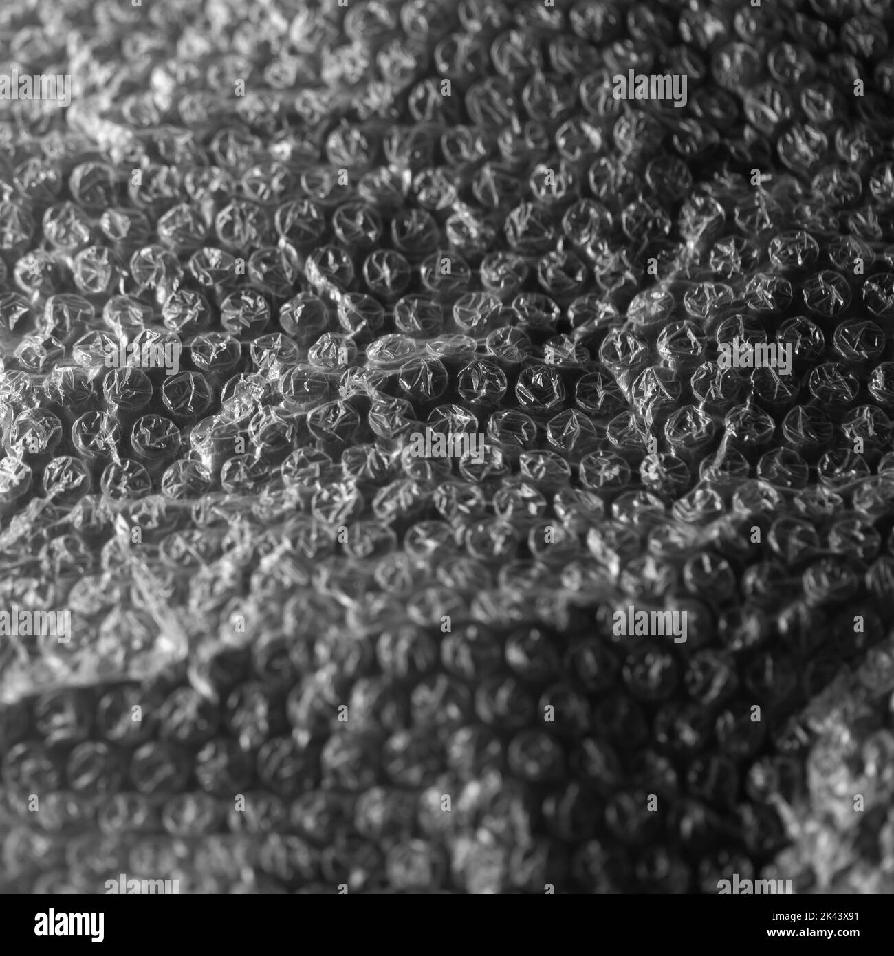 Reflecting light and shadow on creases and tears in plastic bubble wrap ...