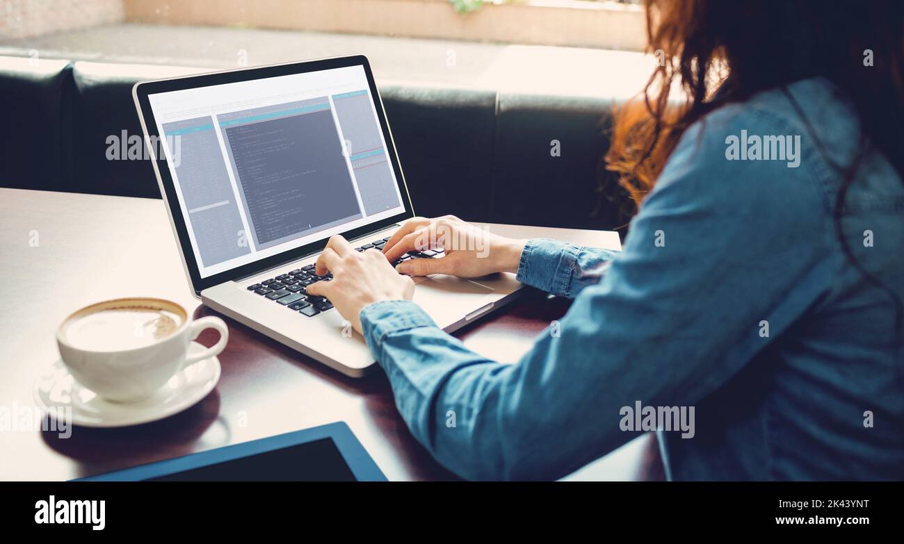 Midsection of caucasian female programmer sitting with coffee, using ...