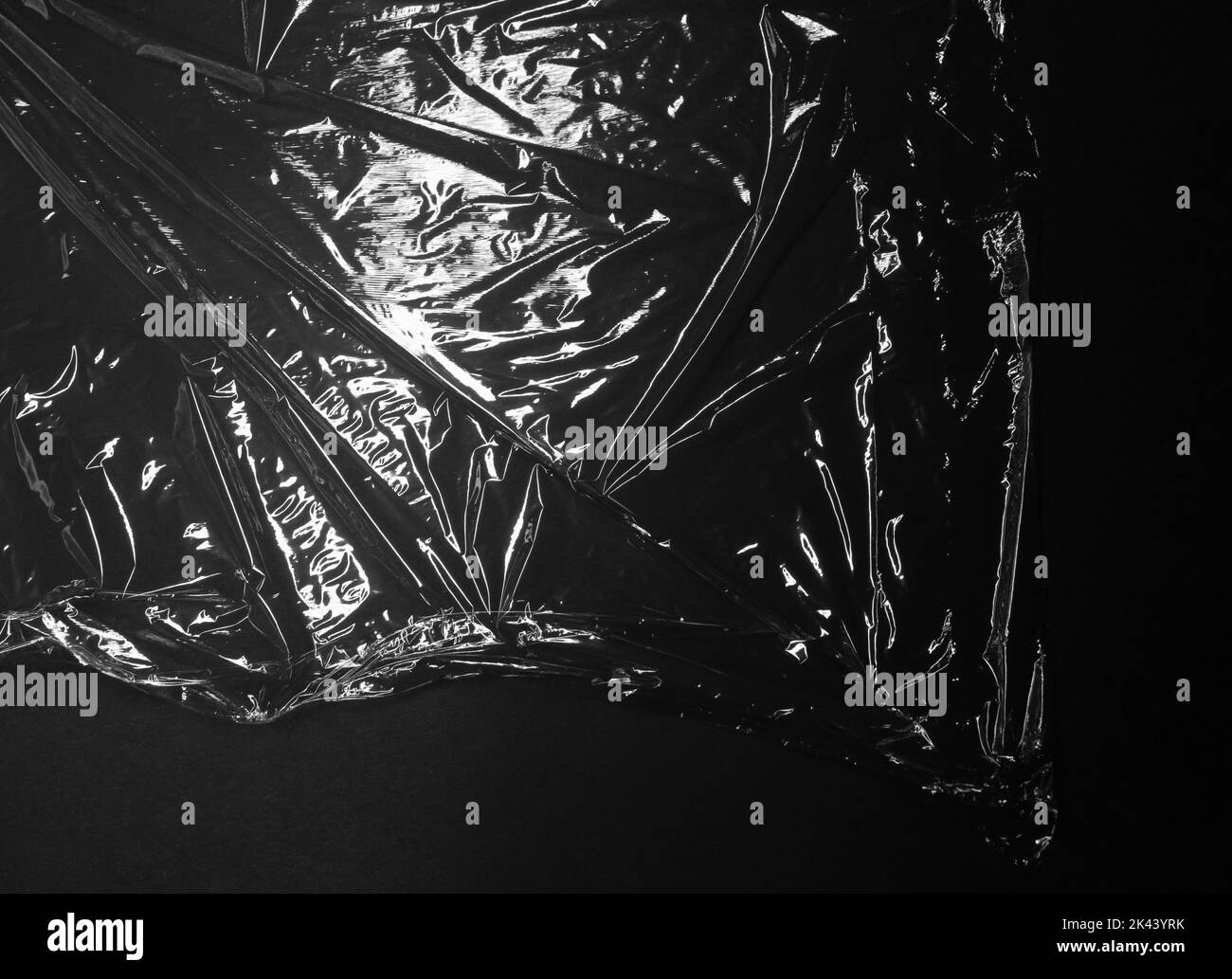 Reflecting light and shadow on creases and folds in clear plastic foil ...