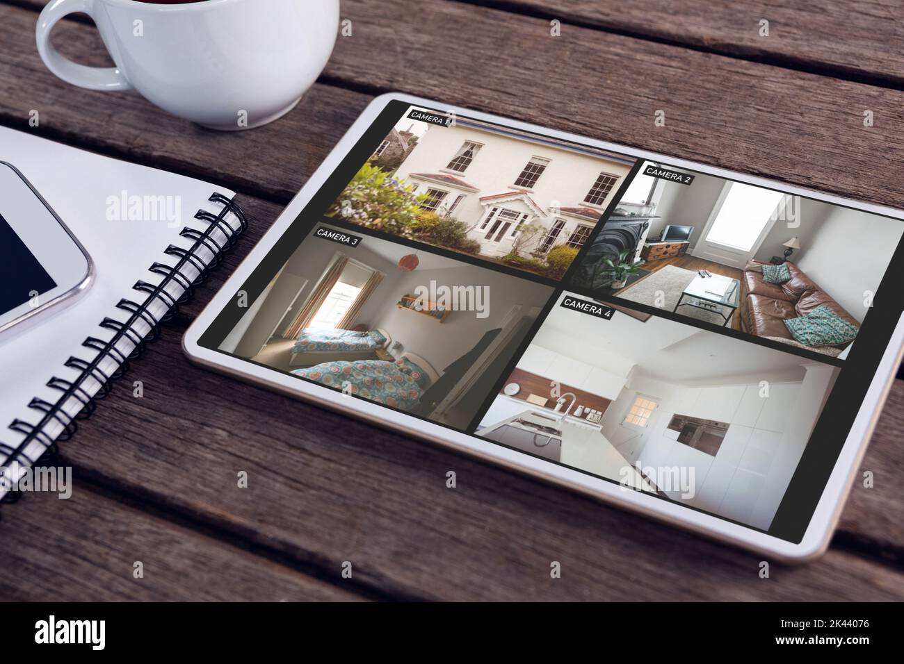 Tablet with view of home from security cameras on screen lying on ...