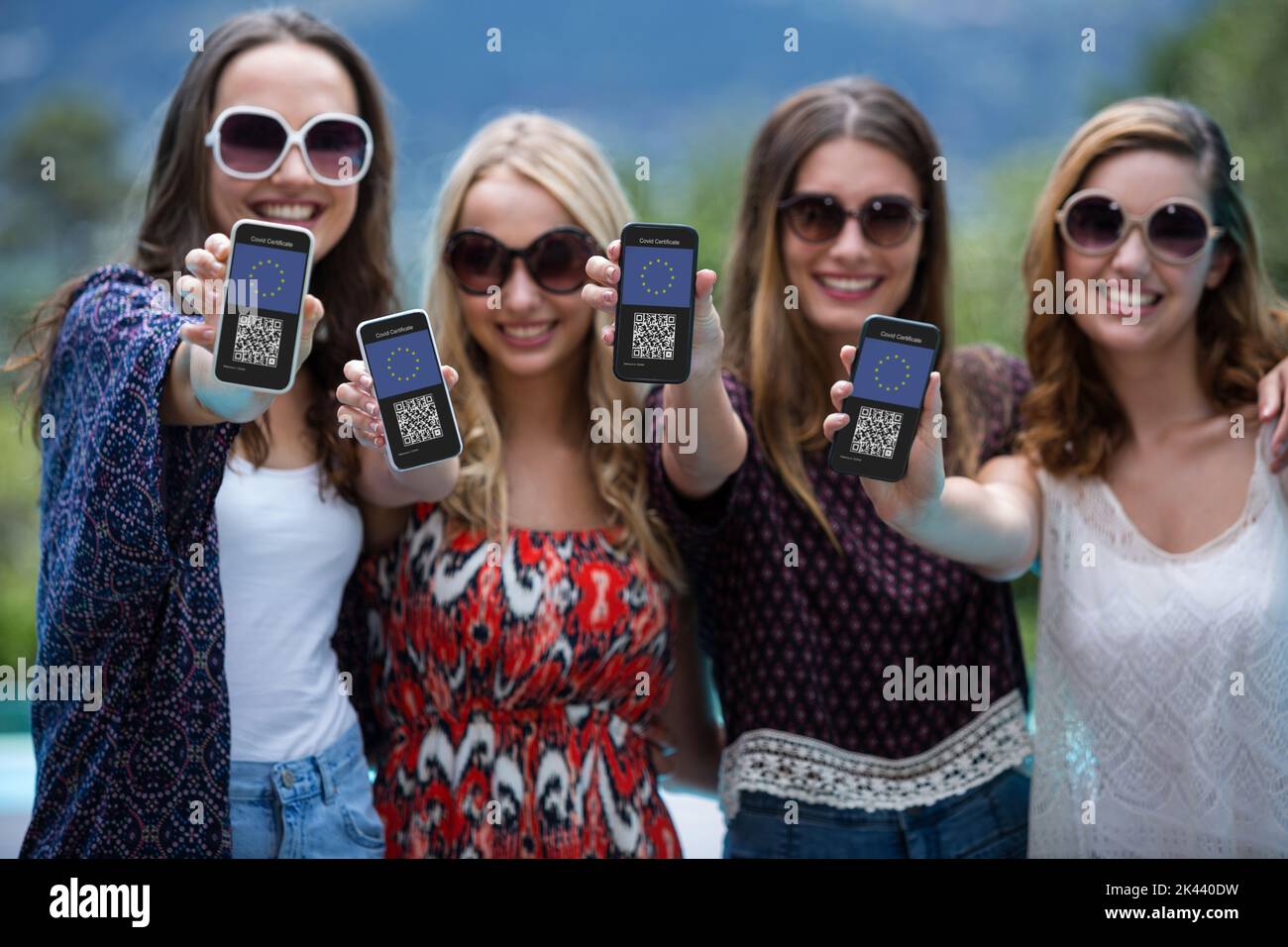 Beautiful women smiling and showing their mobile phones Stock Photo - Alamy