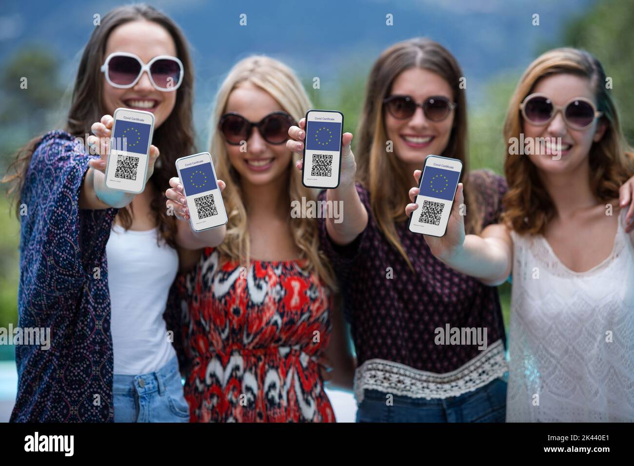 Beautiful women smiling and showing their mobile phones Stock Photo - Alamy