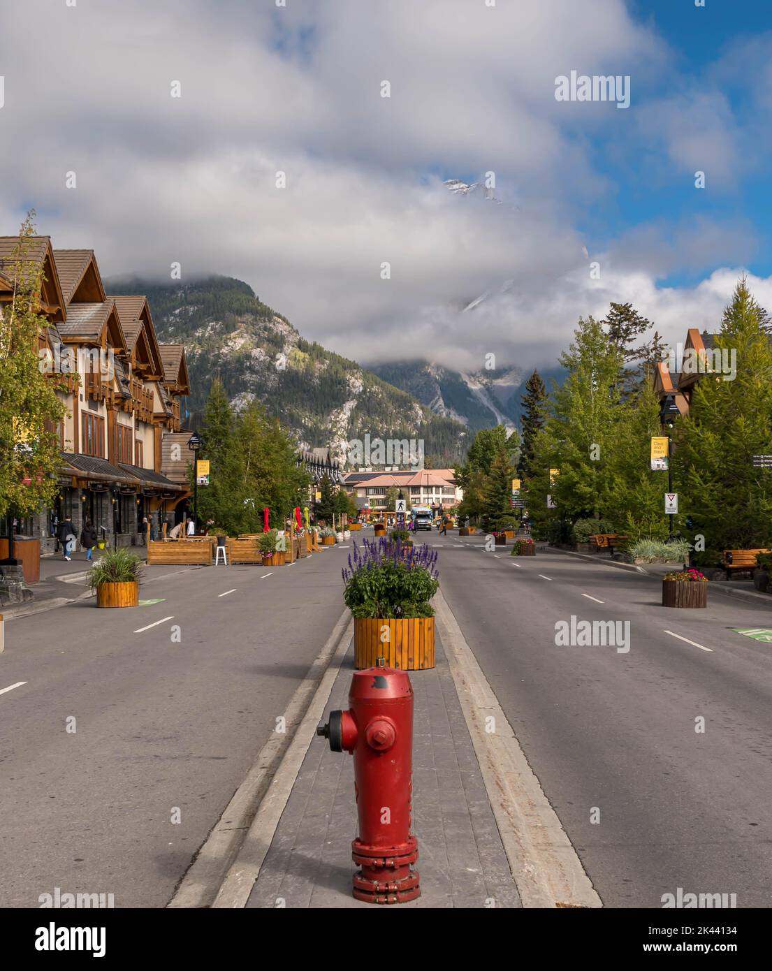 The Banff Avenue business district looking towards a clouded Cascade Mountain in Banff, Alberta ...