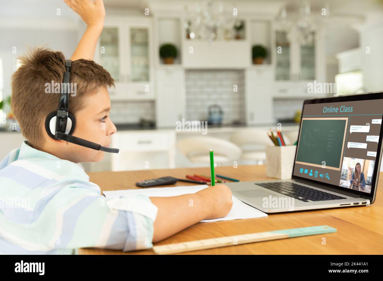 Caucasian boy raising hand for video call, with smiling female teacher ...