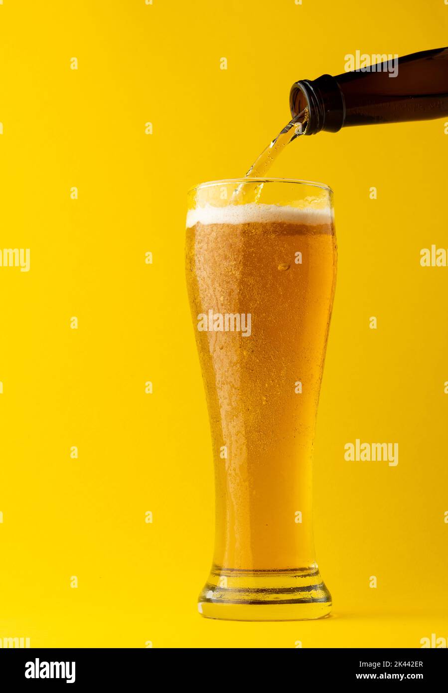 Image of beer bottle pouring into pint glass of lager beer, with copy ...