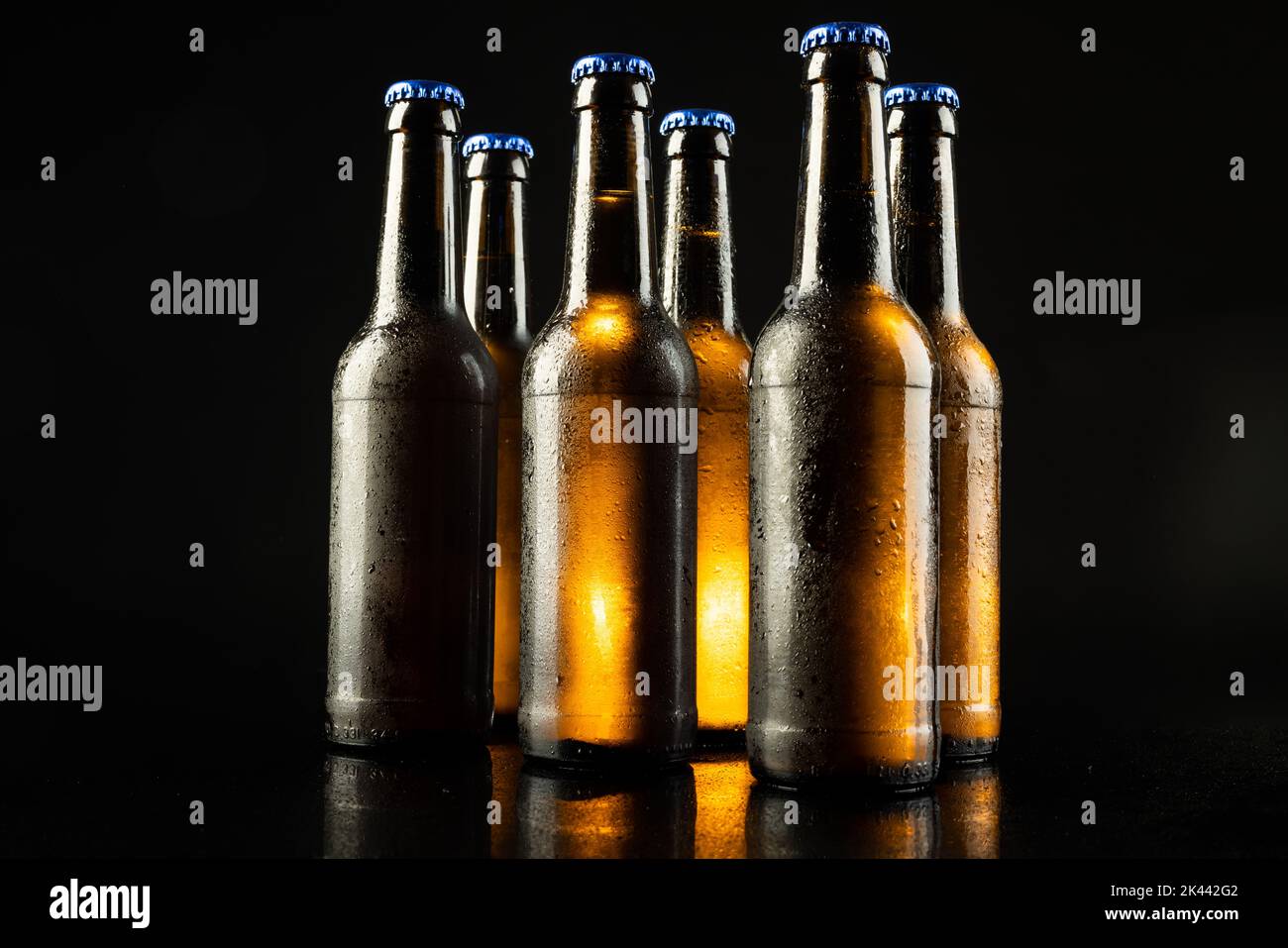 Image of six beer bottles with blue crown caps, with copy space on ...