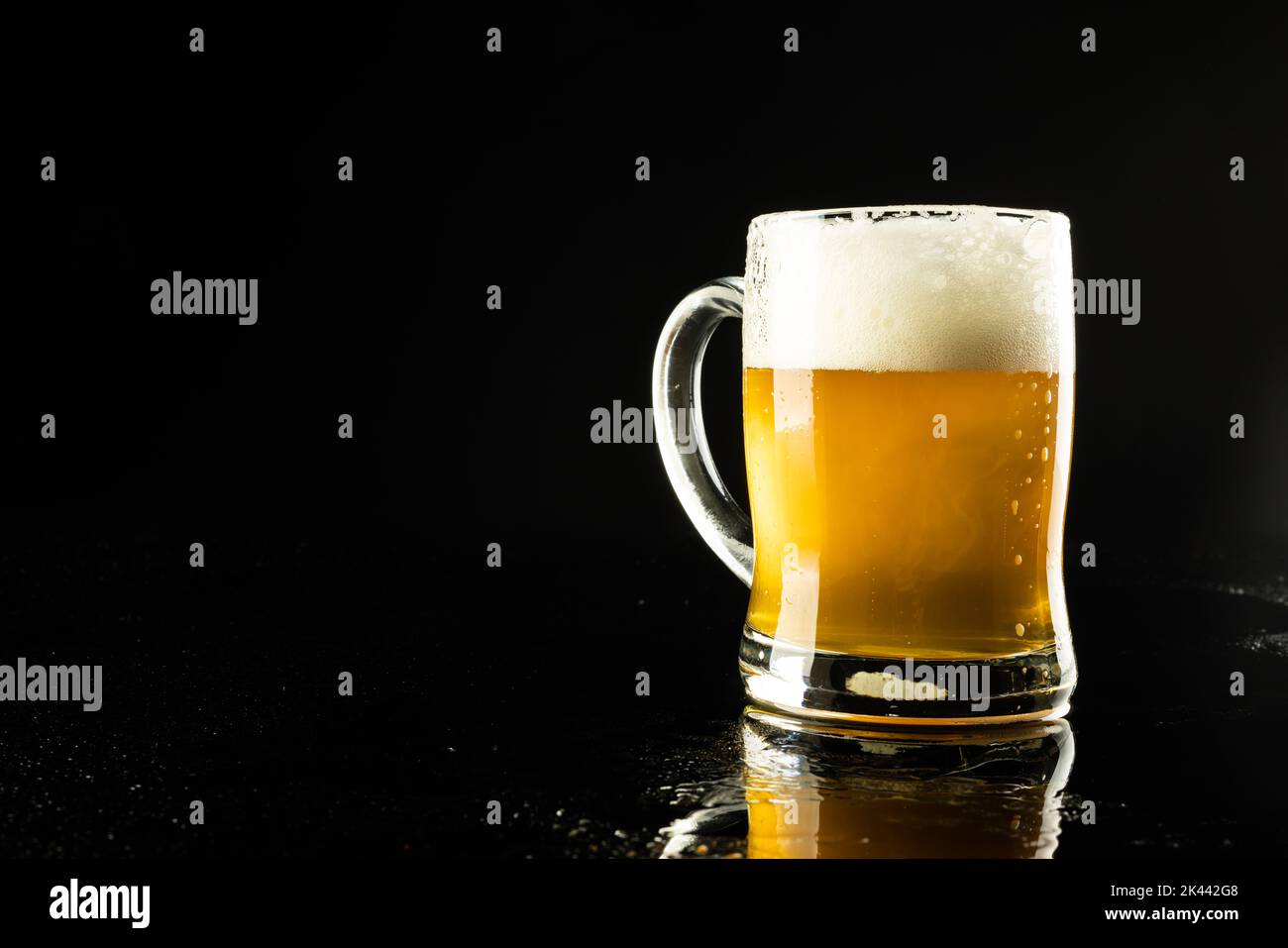 Image of pint glass tankard of foamy beer, with copy space on black ...