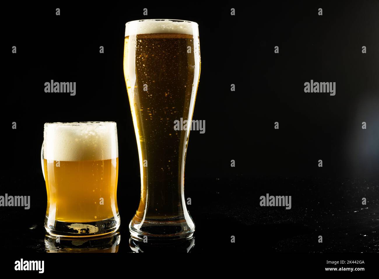 Image of full pint glass and tankard of foamy beer, with copy space on ...